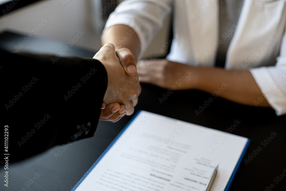 Two businesswomen shake hands after accepting a business proposal ...
