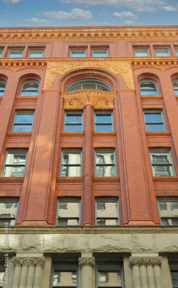 An upward, frontal view of an office building with rusticated sandstone ...