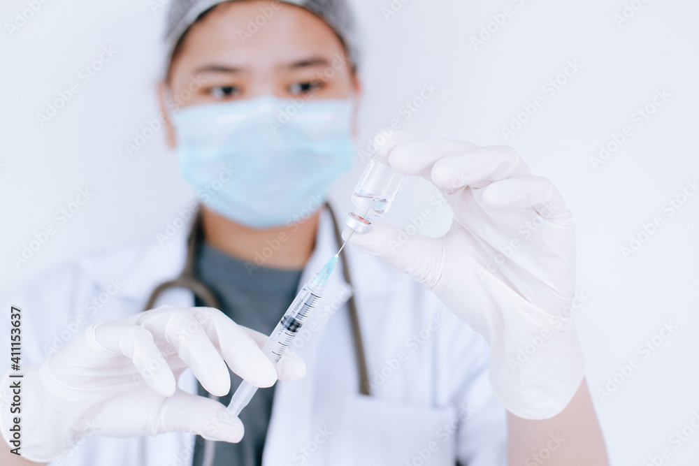 Female doctor or scientist in laboratory holding and filling a syringe ...