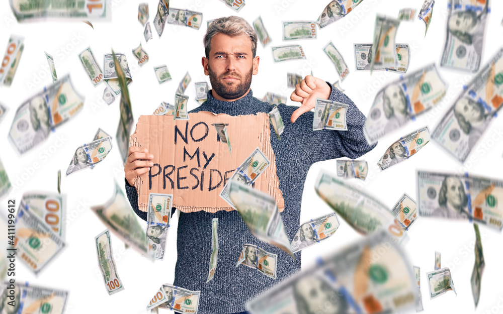 Young handsome blond man holding not my president cardboard banner with ...