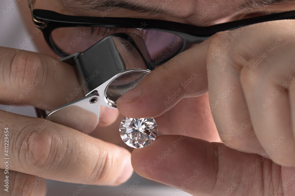Jeweller asian man looking at diamond through magnifying glass. Diamond ...