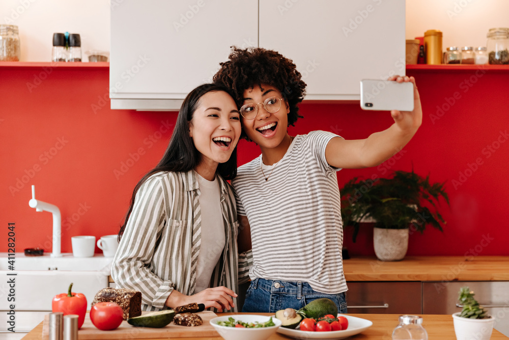 Lovely ladies in white tops pose for selfie while cooking vegetable ...