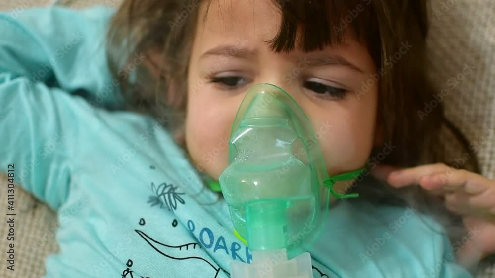 Little kid girl making inhalation with nebulizer at home. Child asthma ...
