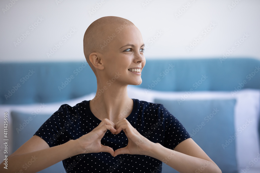 Smiling young Caucasian woman struggle with oncology look in distance ...