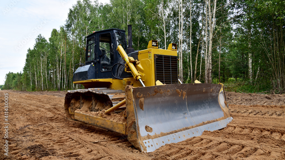 Dozer during clearing forest for construction new road . Yellow ...