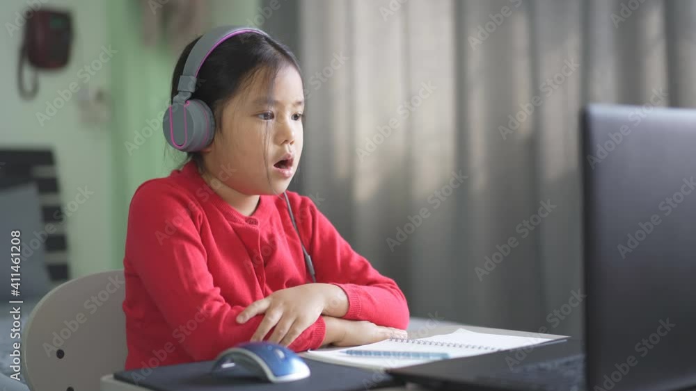 Asian child or kid girl e-learning on computer notebook to wearing ...