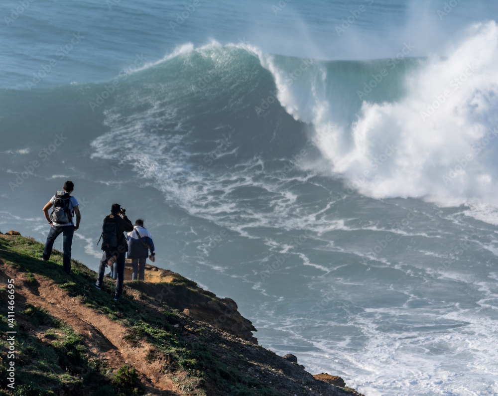 People watching big waves in Nazare, Portugal. In this place the ...