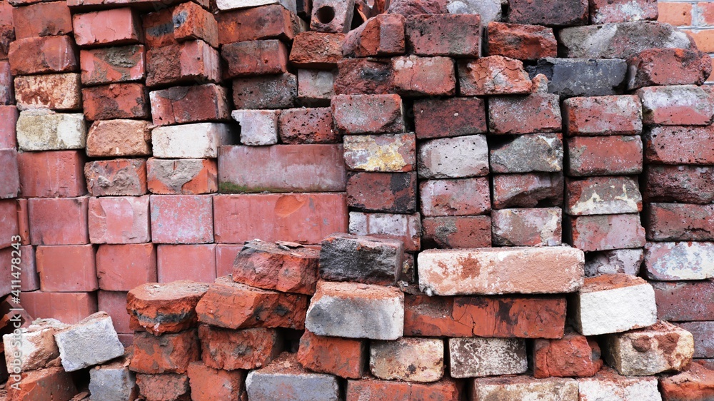 old bright red bricks with white bloom stacked in uneven masonry ...