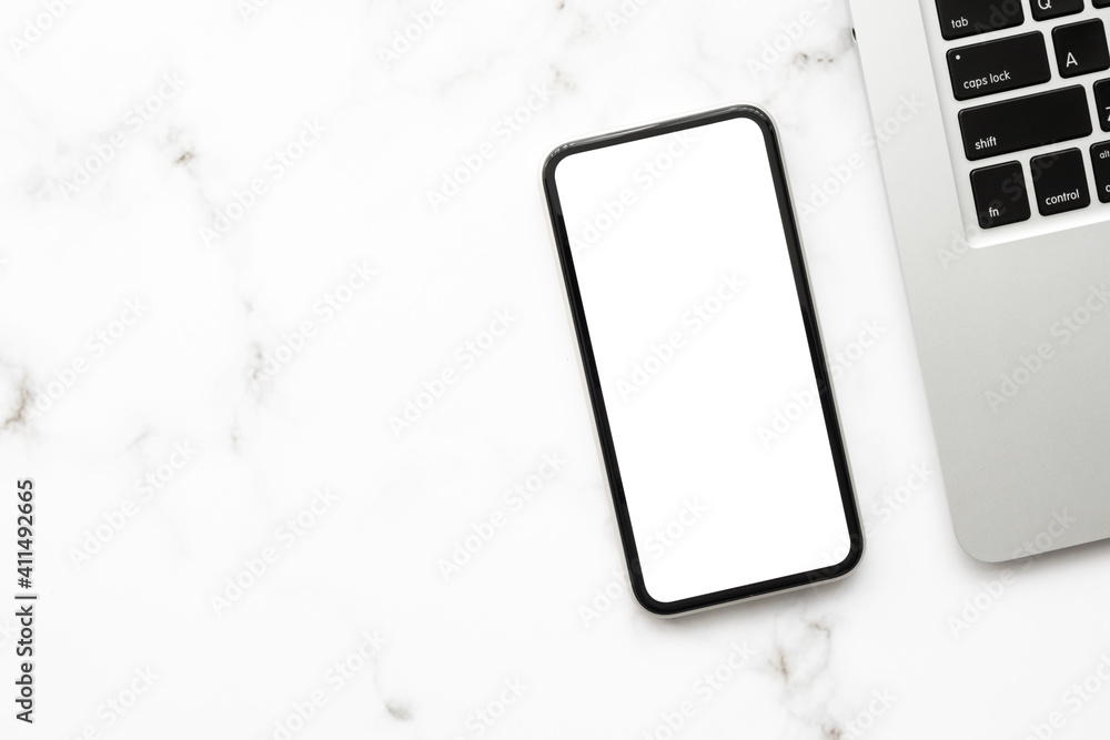 Smartphone with blank screen is on top of white marble office desk ...