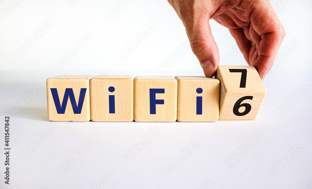 WiFi 6 or 7 symbol. Businessman turns a wooden cube and changes the words WiFi 6 to WiFi 7 ...