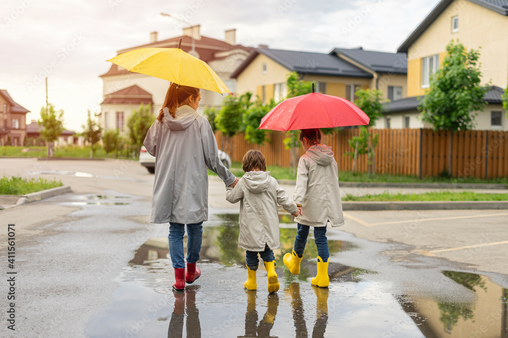 Happy family: mother, daughter, son stand under umbrellas. Mom and ...