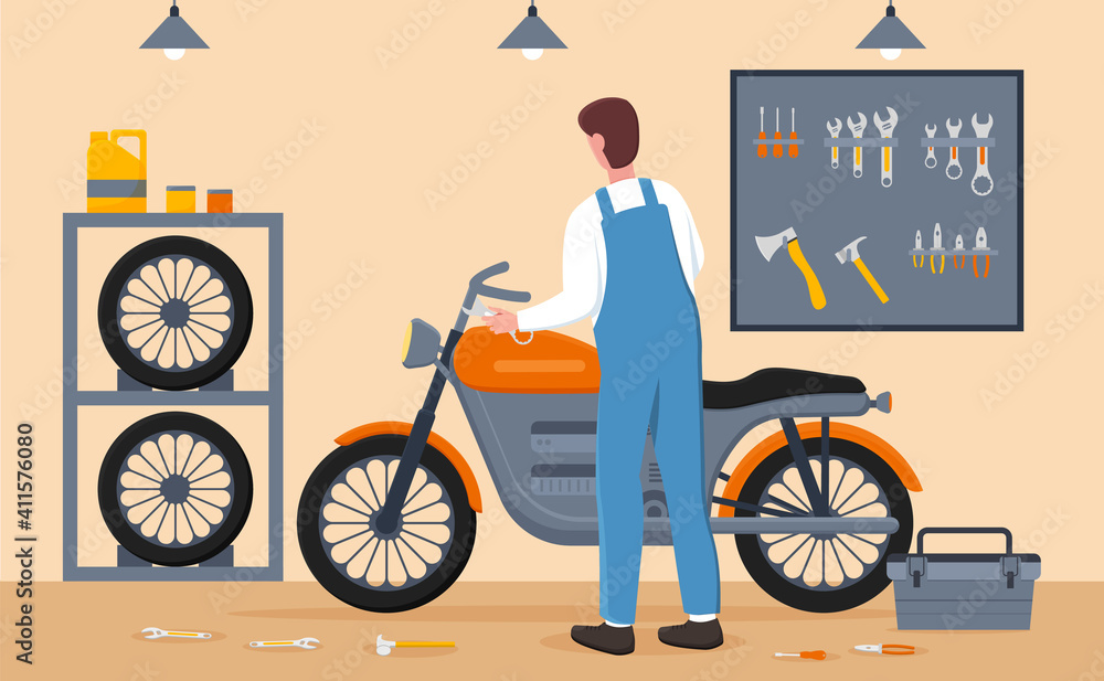 Male mechanic is customizing motorcycle at service garage. Man in ...