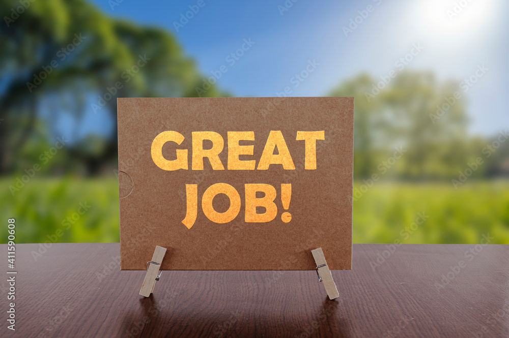 Great job text on card on the table with sunny green park background ...