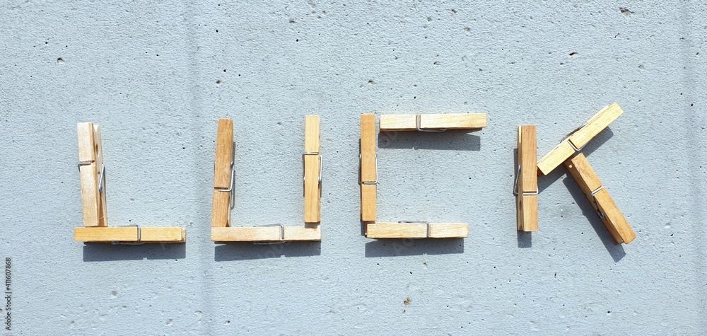 Word "luck", written with tweezers, isolated. Wishes and messages ...