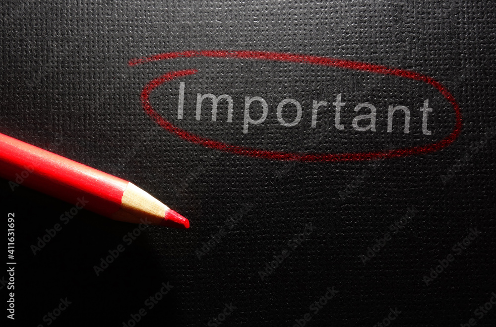 Important text circled in red pencil on black textured paper background ...