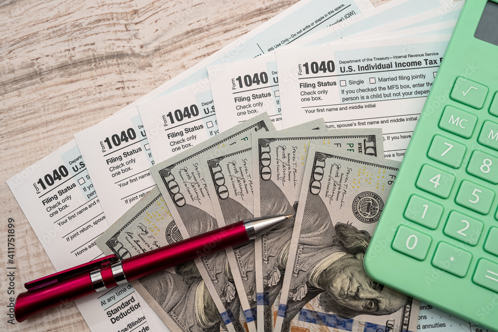 1040 Individual income tax return form with dollar bills and calculator ...