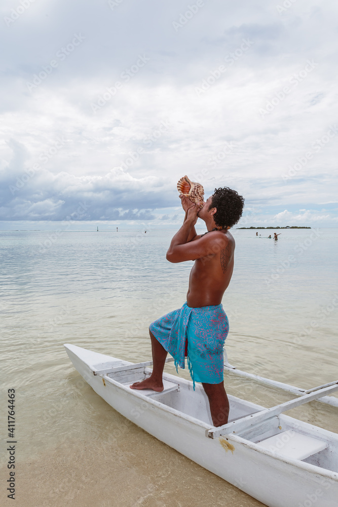 Local tahitian man blowing a conch shell, Moorea, French Polynesia ...