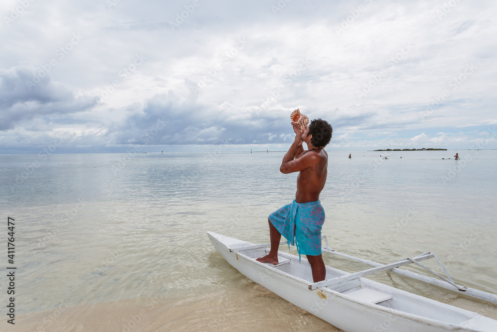Local tahitian man blowing a conch shell, Moorea, French Polynesia ...