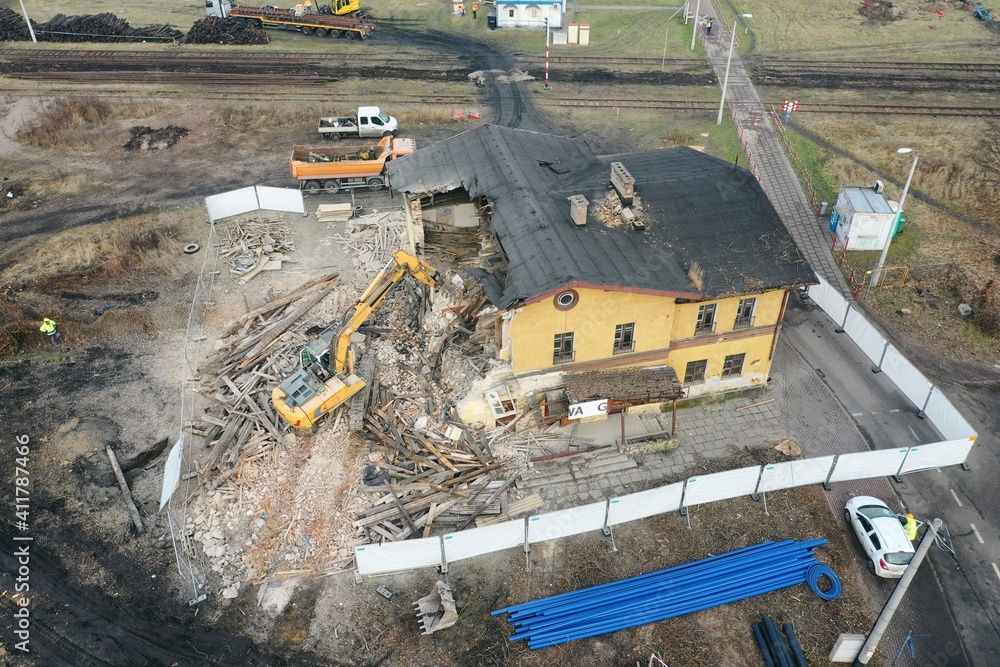 Yellow excavator destroys building. Heavy duty machine is demolishing a ...