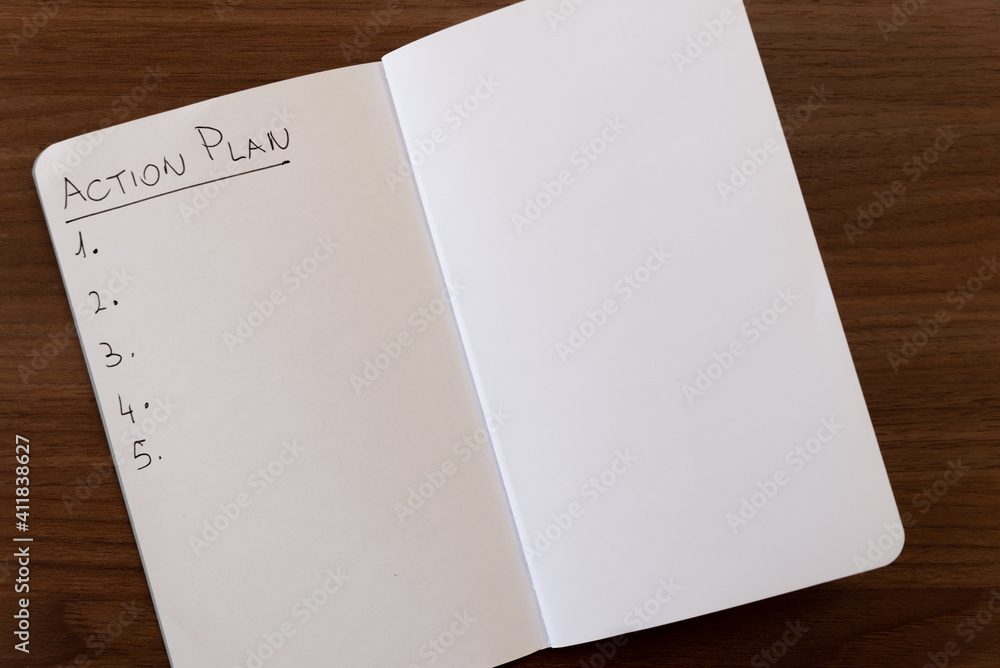 Notebook page marked 'Action plan' in black ink on white paper. Stock ...