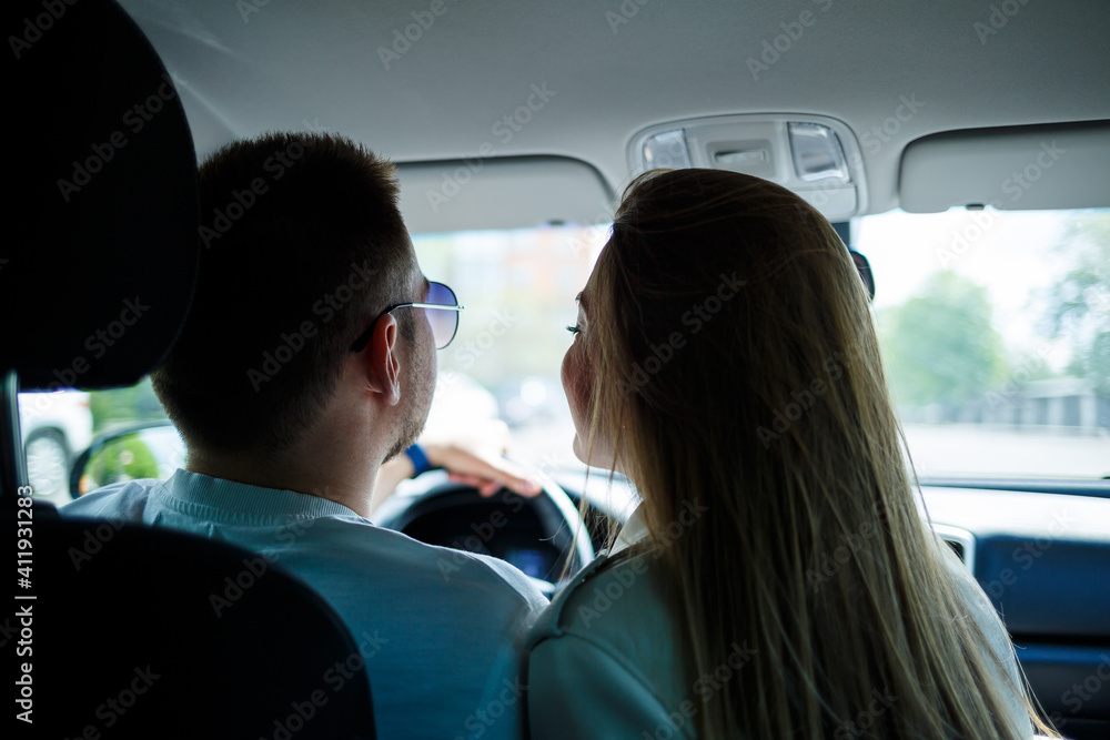 Loving couple in a car hug and hold hands while traveling. Stylish ...