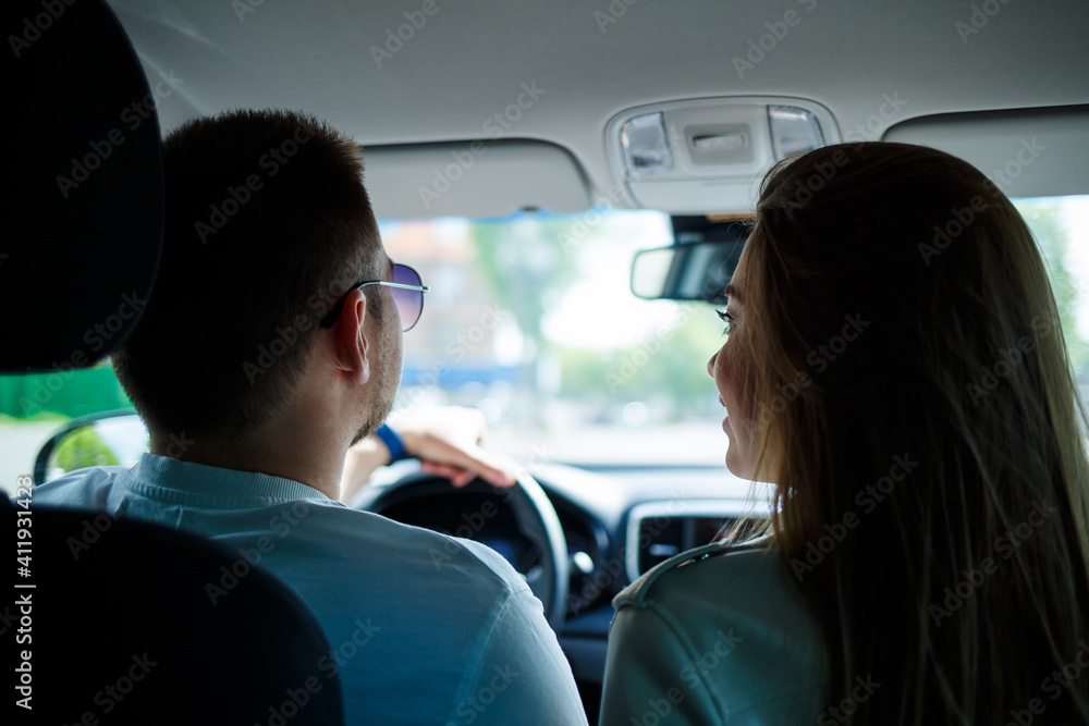 Loving couple in a car hug and hold hands while traveling. Stylish ...