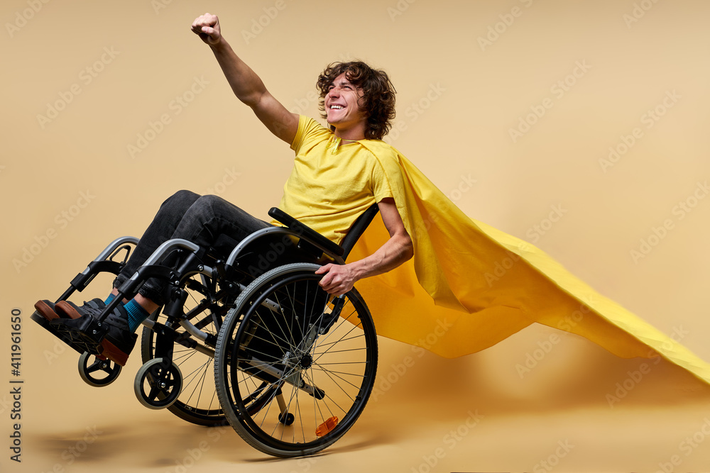 happy disabled man in yellow cloak pretend to be superhero, raising ...