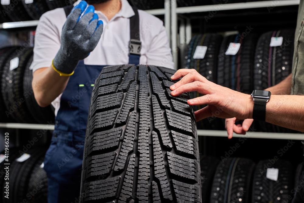 close-up photo of car tire, focus on black tire, customer examining the ...