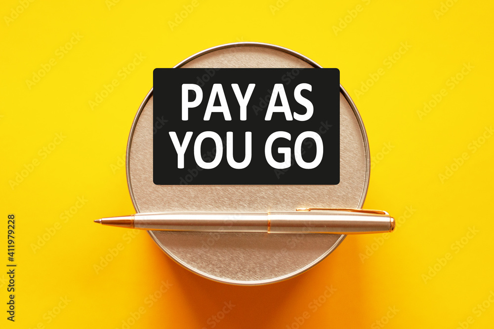 PAY AS YOU GO - words on a black sheet on a yellow background with ...