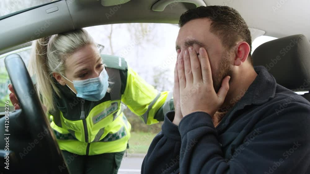Stockvideo Female paramedic medic wearing face mask assessing injuries ...