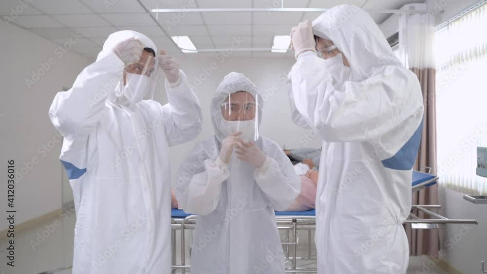 Doctors and nurses standing and checking protective equipment suit ...