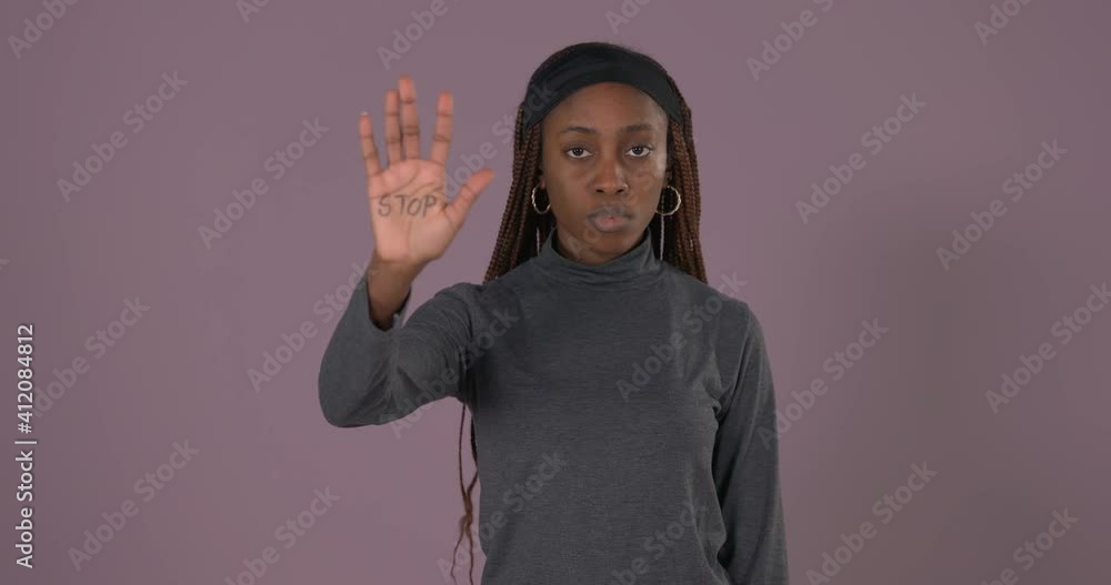 Portrait of African woman raising hand with stop inscription on palm ...