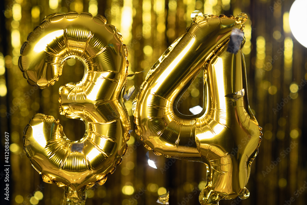 The golden number 34 thirty four is made of an inflatable balloon on a ...