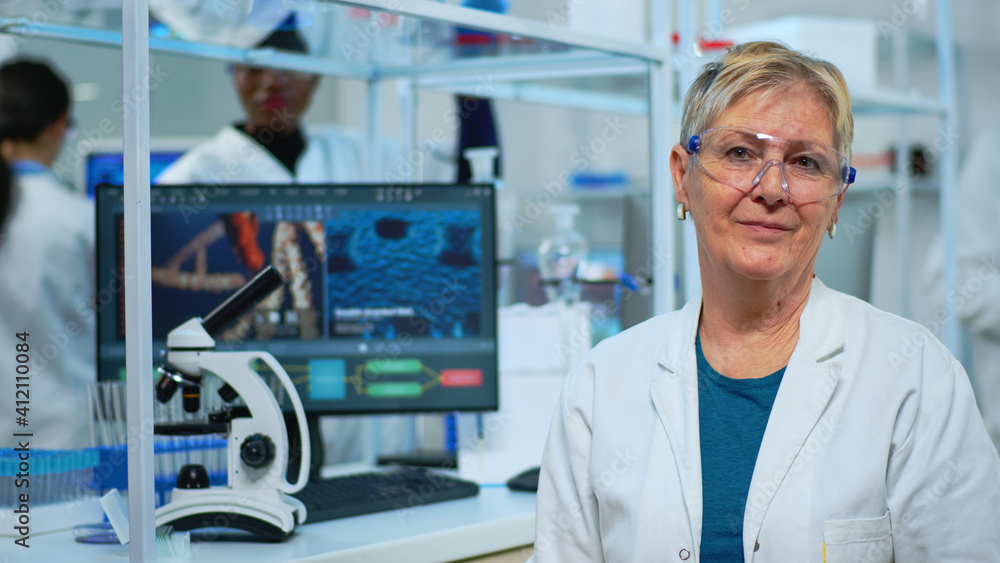 Portrait of old scientist woman smiling at camera in modern equipped ...