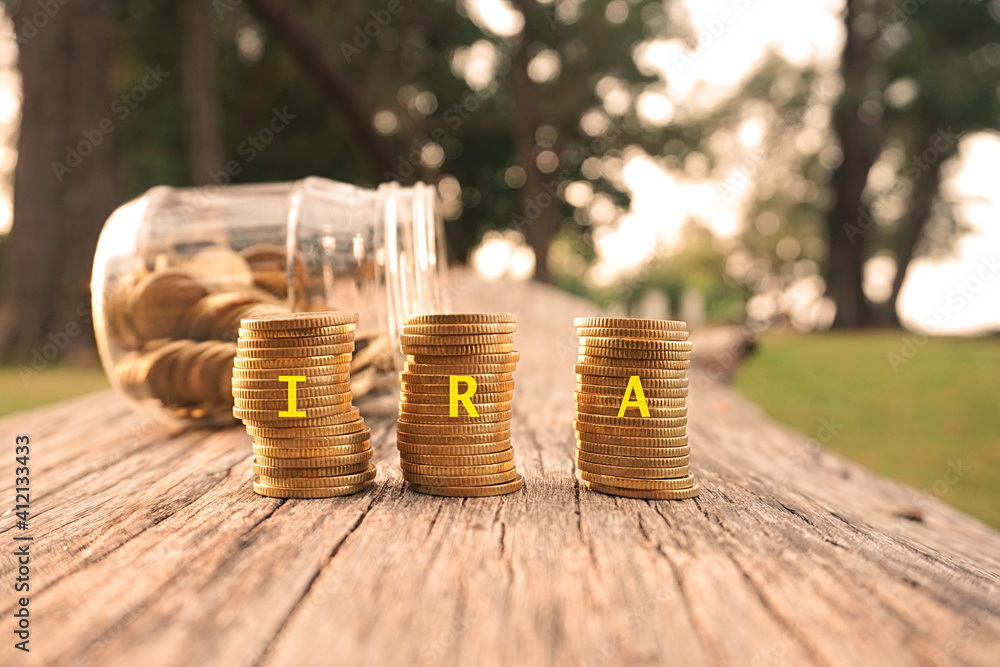 Close up of stacking gold coins written IRA on nature background and ...