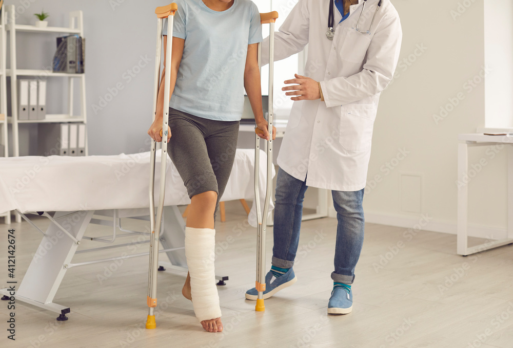 Zdjęcie Stock: Patient with broken leg assisted by doctor. Injured ...