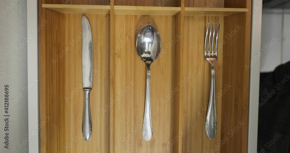 One piece of all types of cutlery in the drawer of the kitchen cabined ...