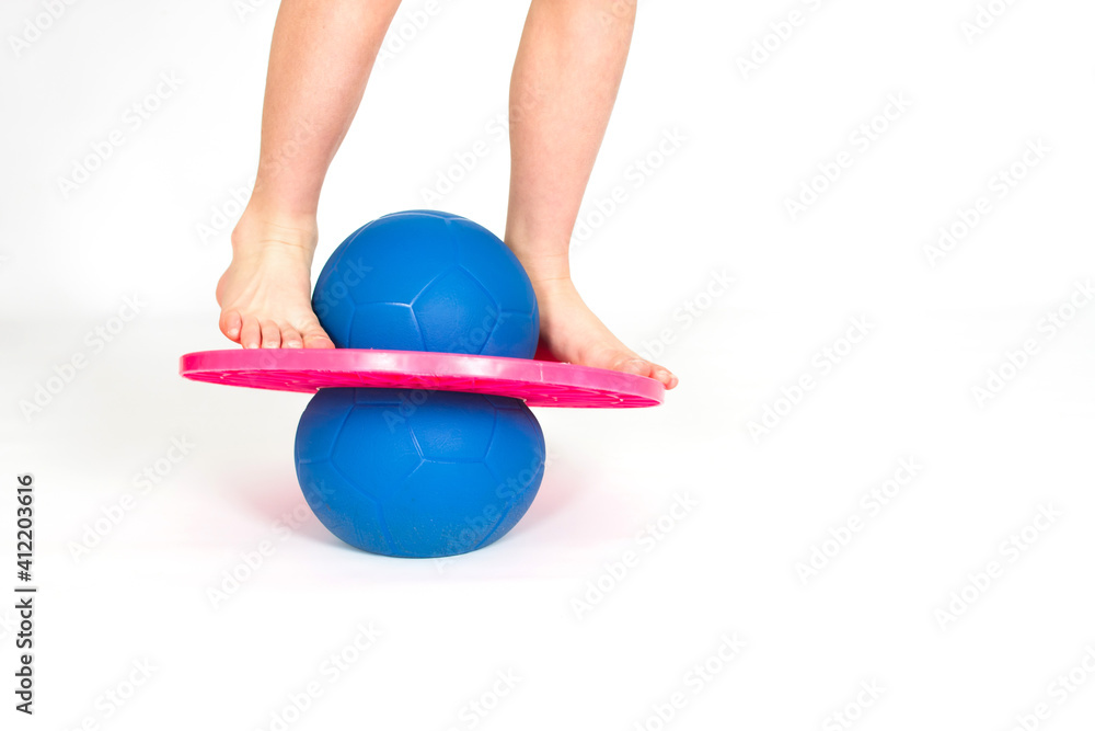 Kids legs on balance trainer isolated on white background. Bouncy ball ...
