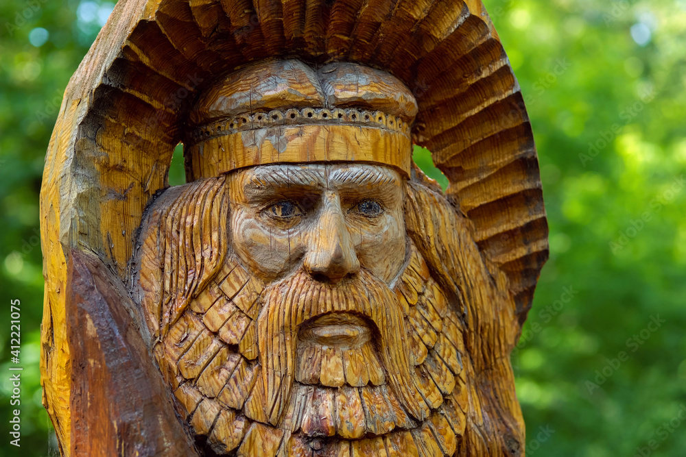 Old man wooden statue between trees. Pagan idols on forest. Ancient ...