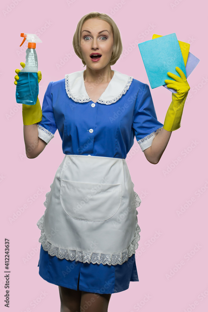 Full-sized portrait of surprised blonde housekeeper. Middle-aged ...