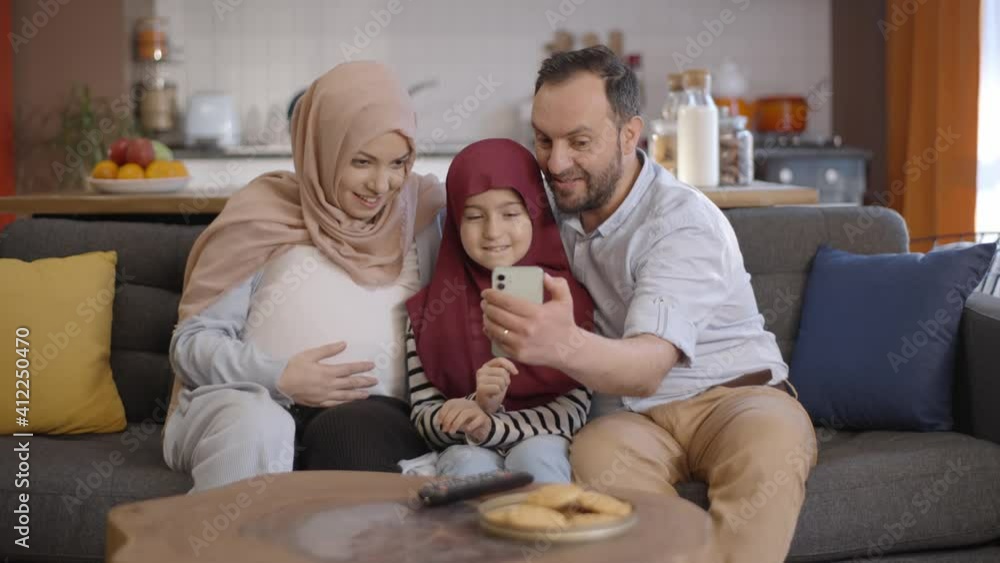 Muslim family video chatting on the phone.While the Muslim family is ...