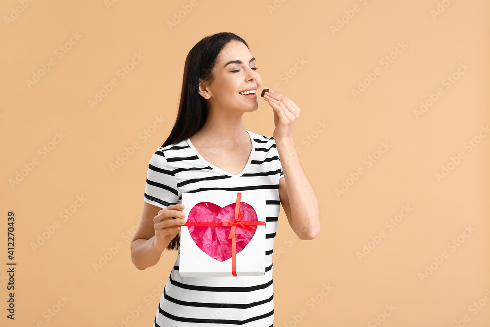 Beautiful young woman with candies on color background. International ...