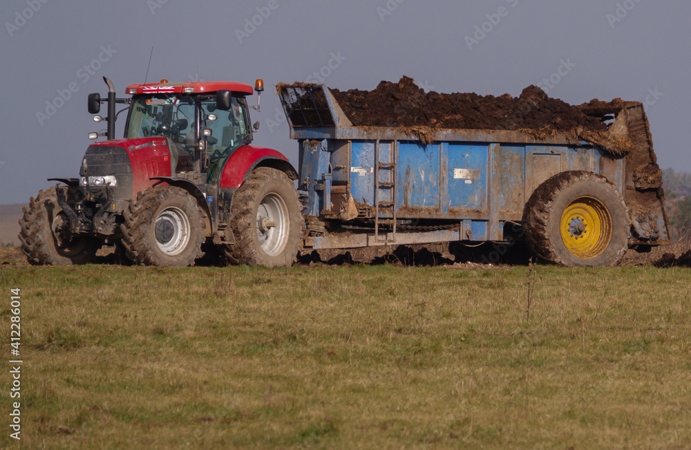 Case Puma 160 CVX tractor offloading a trailer full of manure in the ...