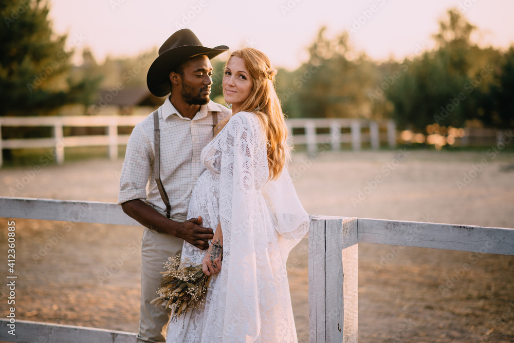 Interracial family. African man hugs his pregnant Caucasian wife ...