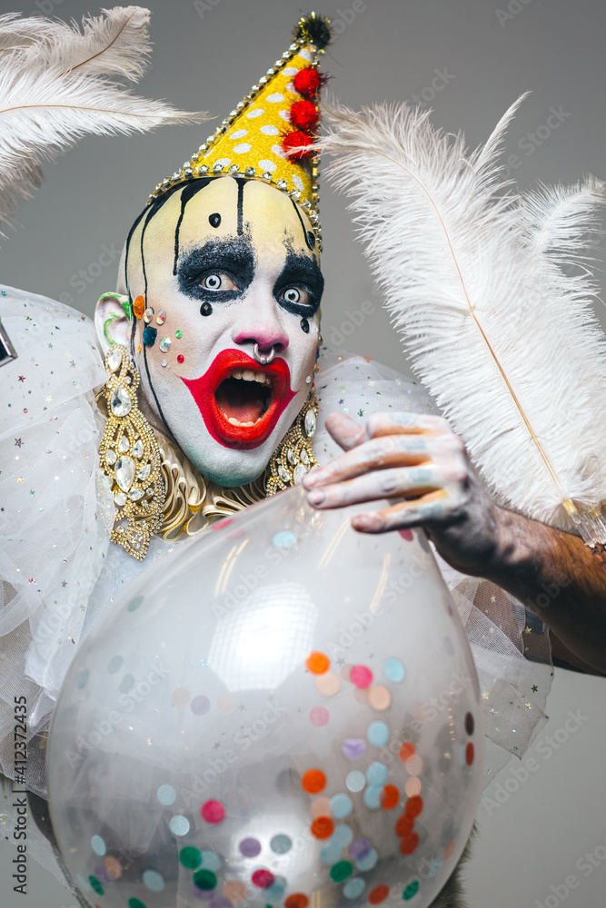 Grotesque clown with confetti balloon Stock Photo | Adobe Stock