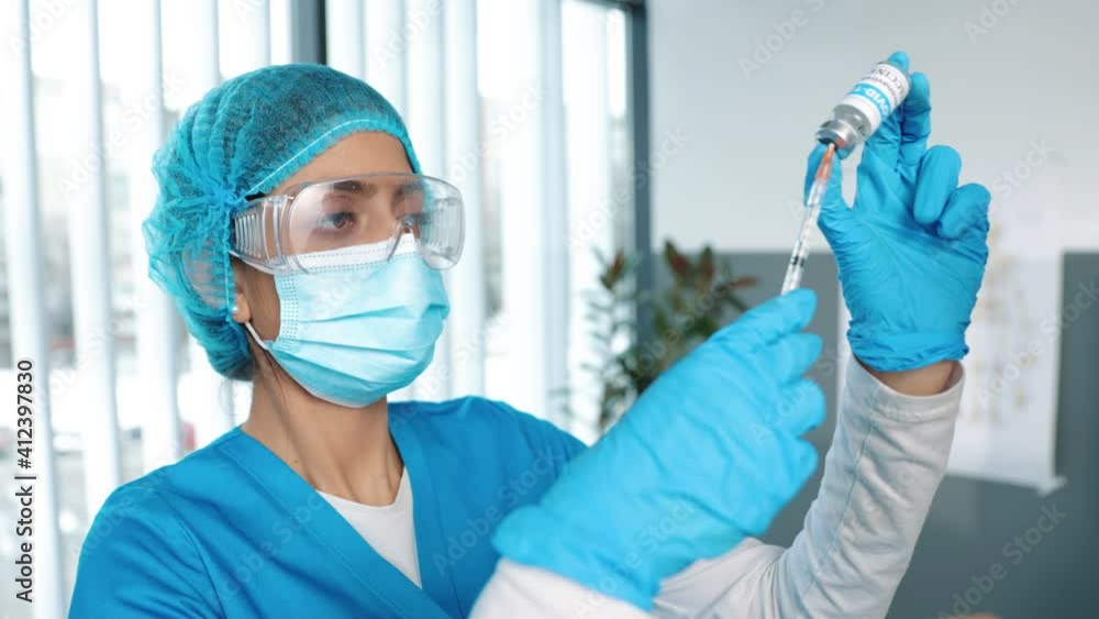 COVID-19 coronavirus vaccine. Doctor scientist with syringe analyzing ...