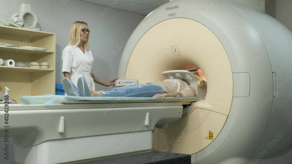 Woman doctor radiologist makes brain, head, neck MRI scanning. Young ...
