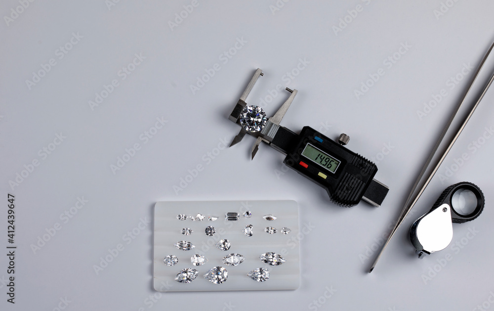 layout of jewelry tools and diamond of different cuts and sizes on ...