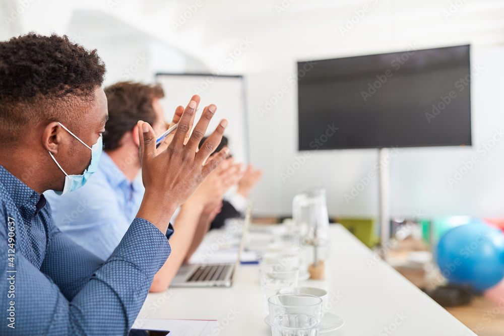 Man in face mask applauds at video conference Stock Photo | Adobe Stock
