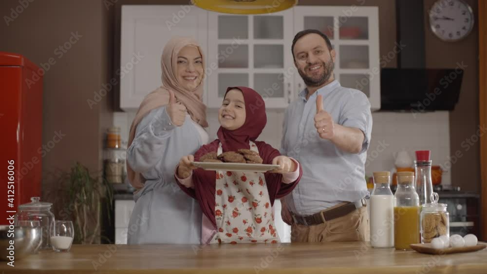 The Muslim family poses proudly showing the cookie they made.Muslim ...